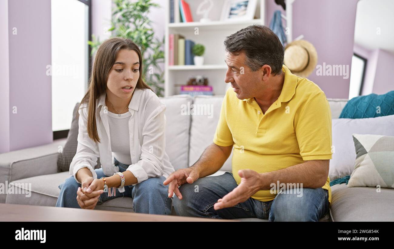 Serious father and daughter arguing on sofa at home, a strained family ...