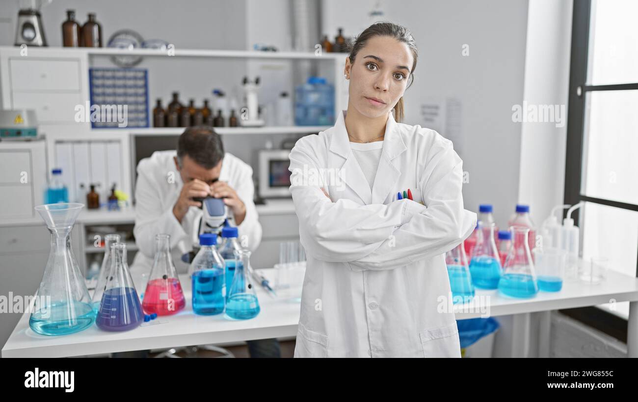 Two determined scientists, a man and woman, work together in a lab ...