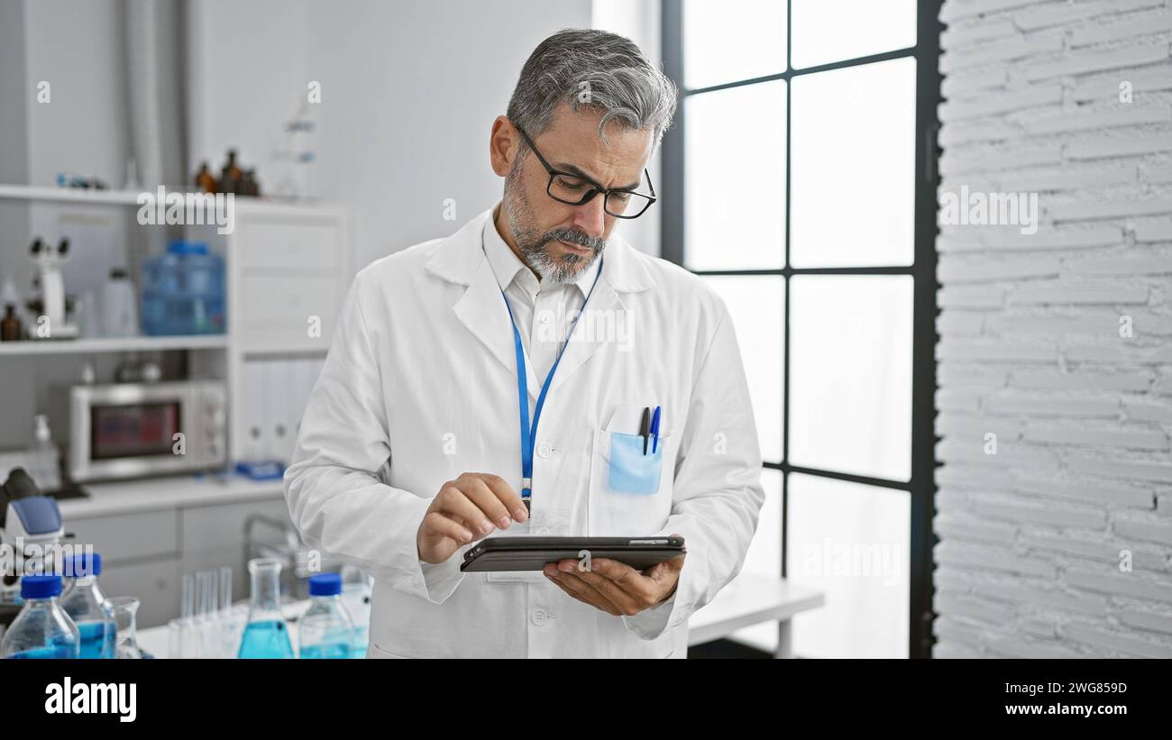Young hispanic grey-haired man scientist using touchpad at laboratory Stock Photo - Alamy