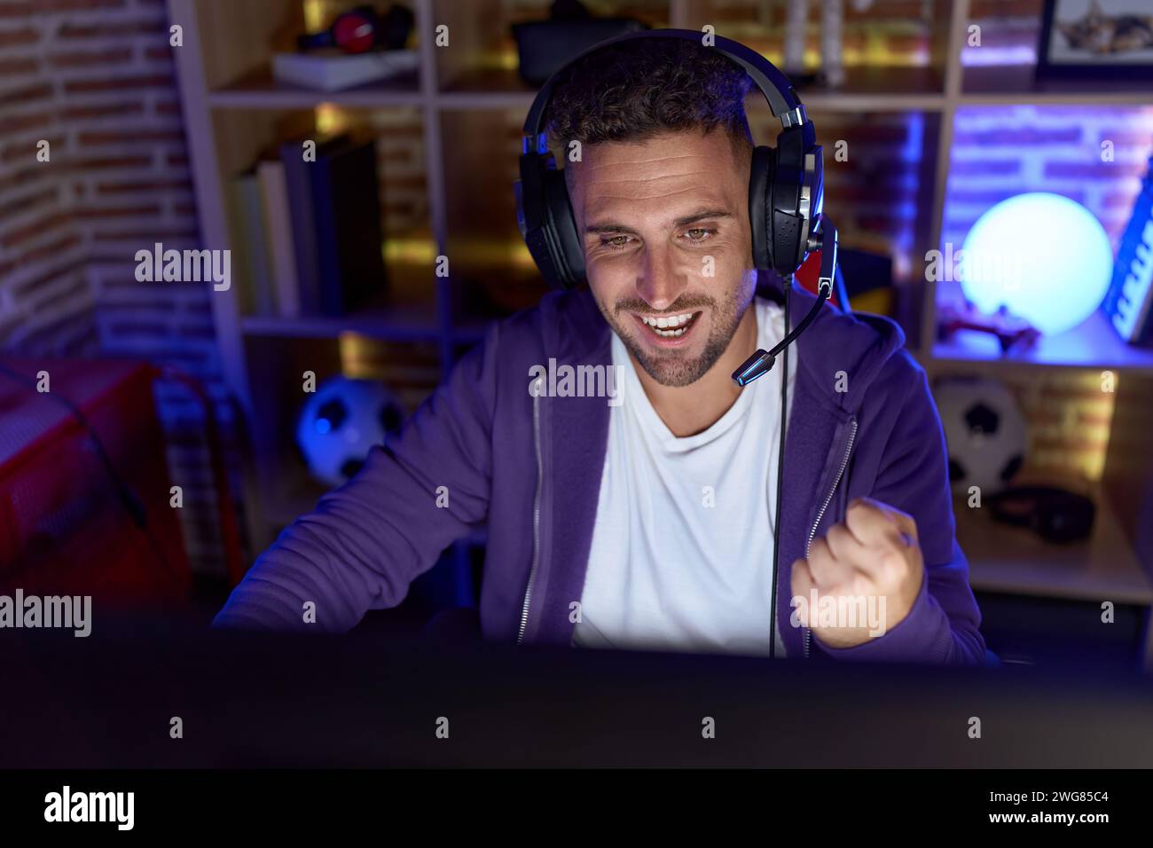 Young hispanic man streamer playing video game with winner expression ...