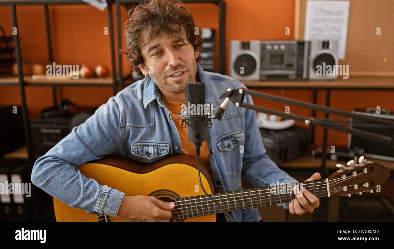 A handsome hispanic man recording music in a studio while playing an ...