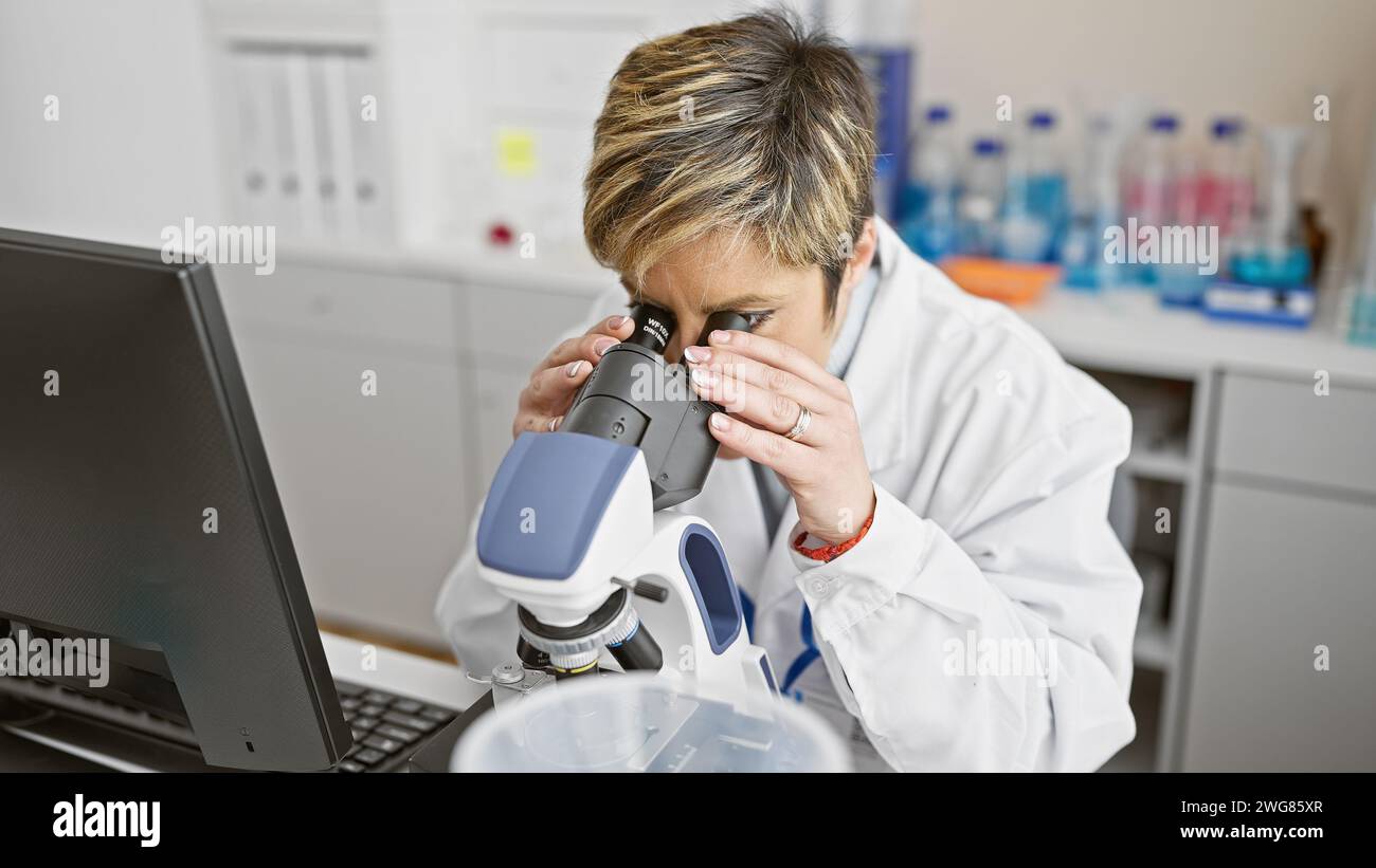 Woman studying samples through microscope hi-res stock photography and ...
