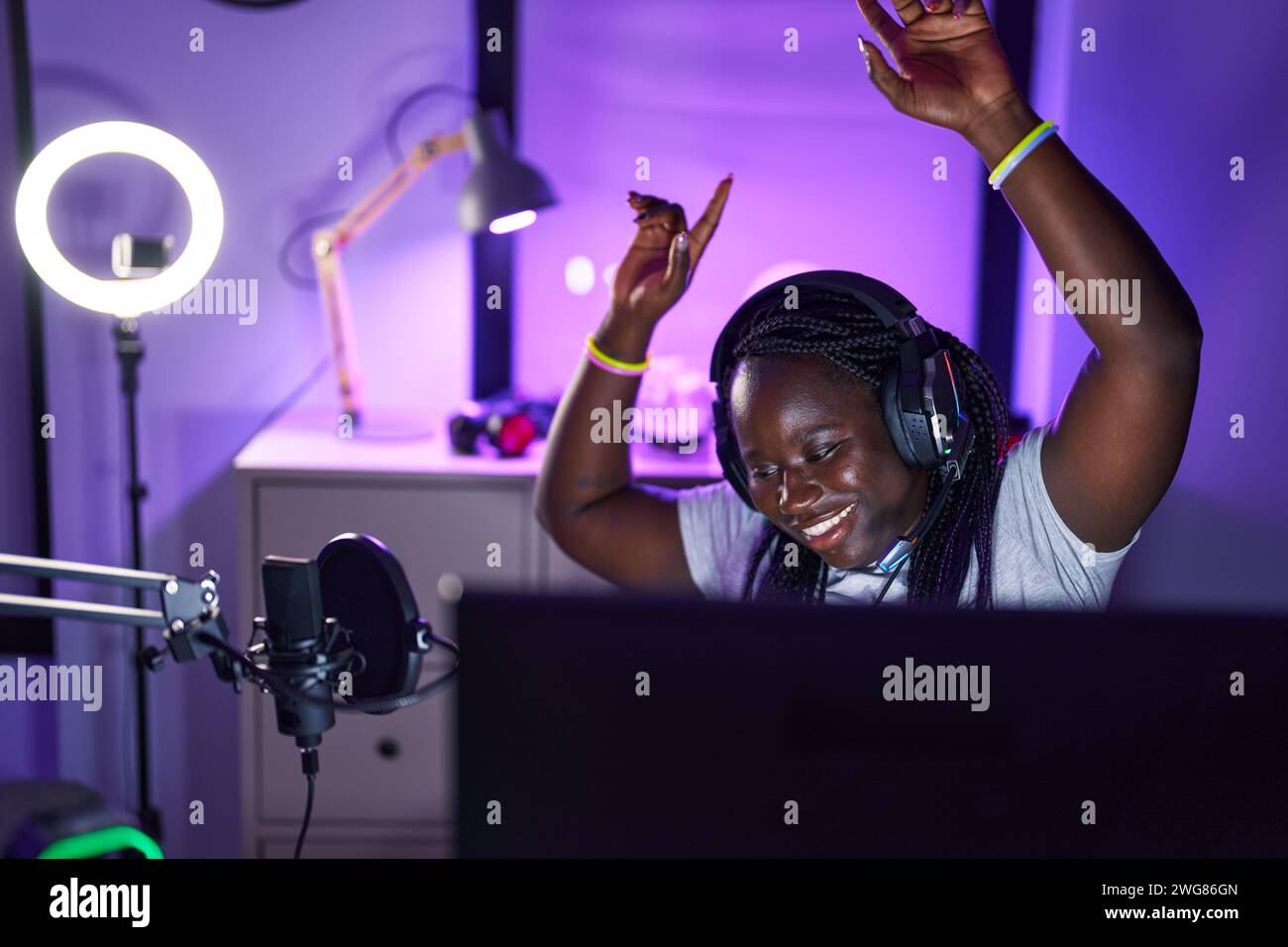 African american woman streamer playing video game dancing at gaming ...