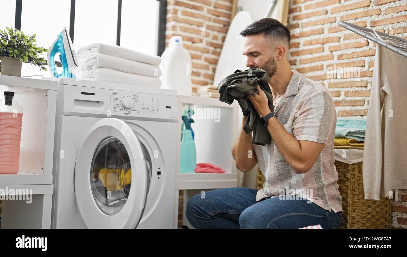 Young hispanic man sitting on floor with serious face smelling dirty ...