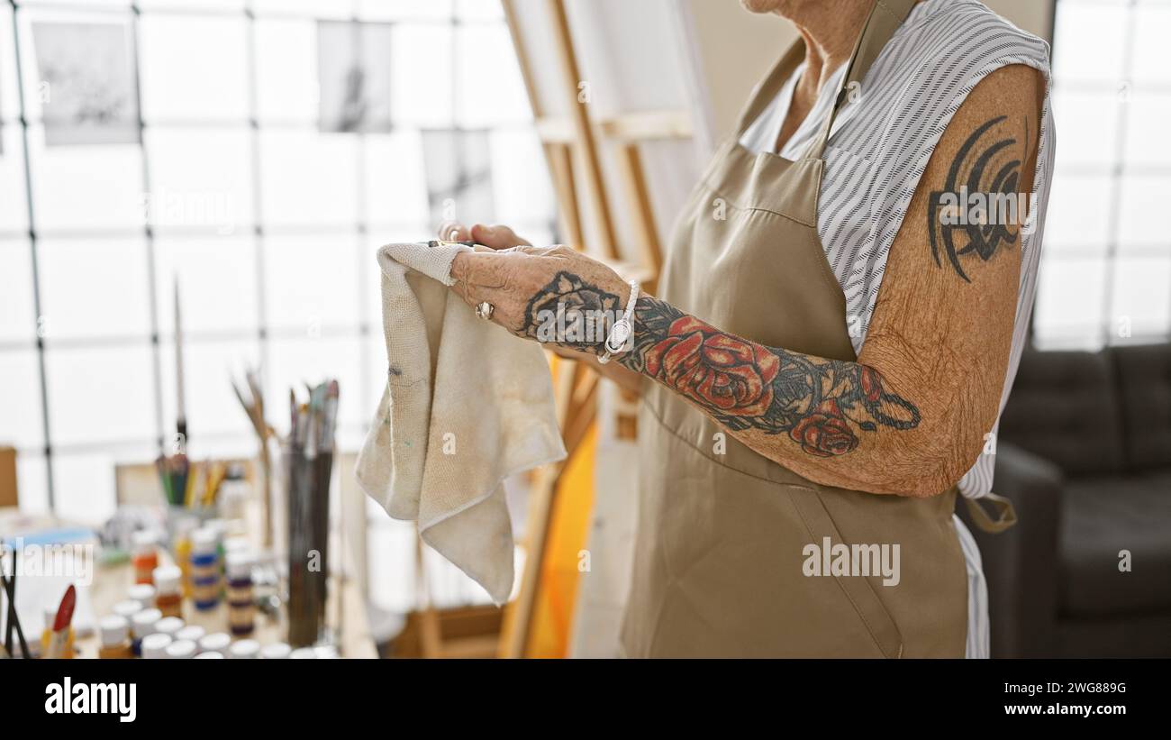Indoor art school's joy, hands of senior woman artist lovingly cleaning ...