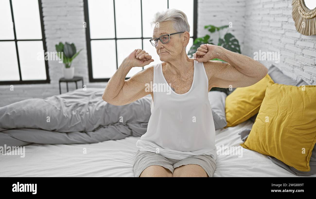 Elderly grey-haired woman enjoying a morning stretch, waking up in the ...