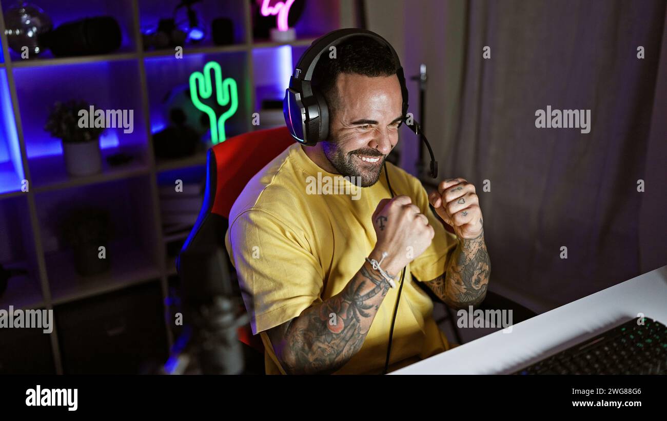 Hispanic man laughs while gaming in a dark room with neon lights Stock ...