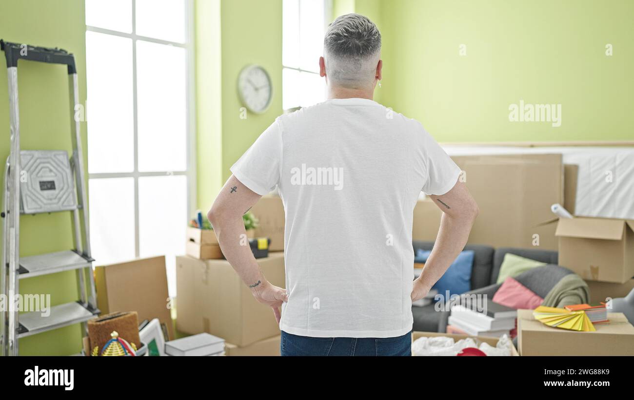 Young caucasian man standing backwards at new home Stock Photo - Alamy