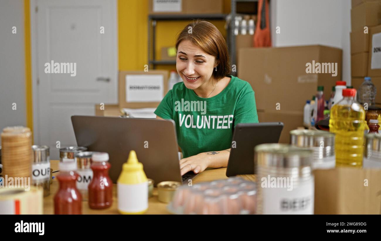 Young woman volunteer using laptop and touchpad smiling at charity ...