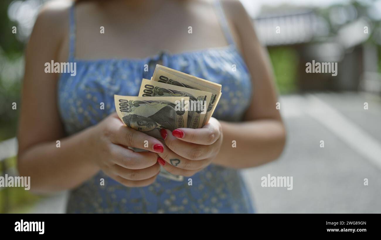 Young woman's hands, busy counting yen banknotes in the traditional ...
