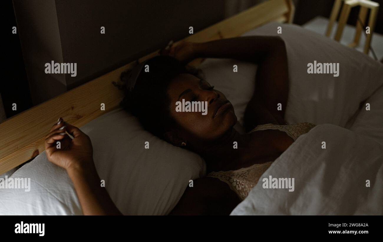 African american woman lying on bed sleeping at bedroom Stock Photo - Alamy