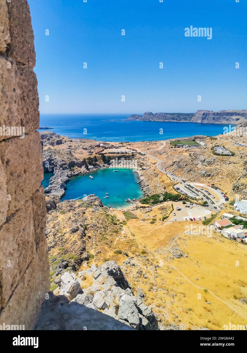 View of St. Paul's Bay in Lindos. Rocks surround the sea in the shape ...