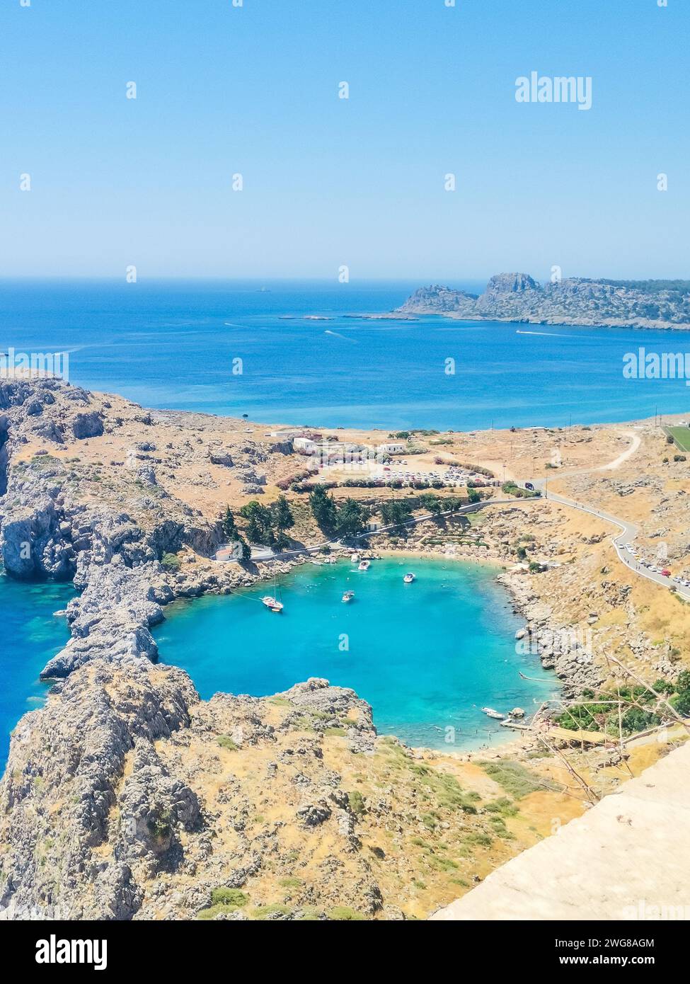 View of St. Paul's Bay in Lindos. Rocks surround the sea in the shape ...