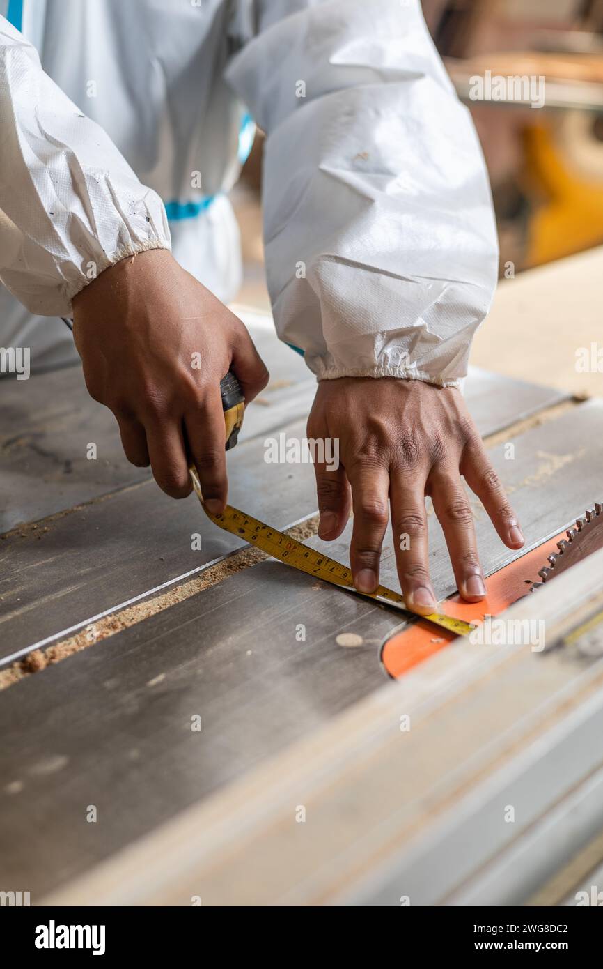 hands of a young man measuring machine to perform saw cutting, interior ...
