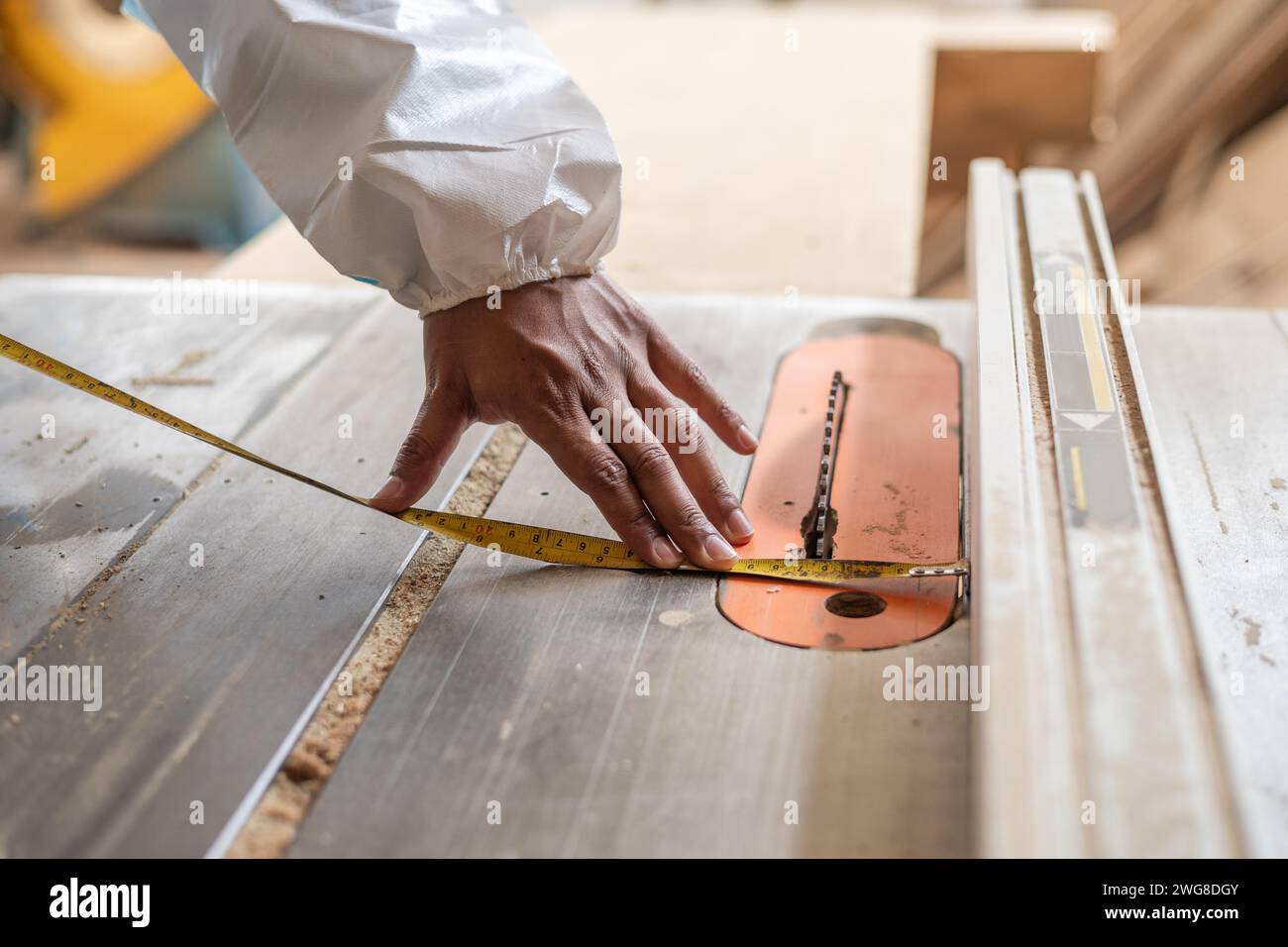 hands of person preparing machine to cut with saw, interior of ...