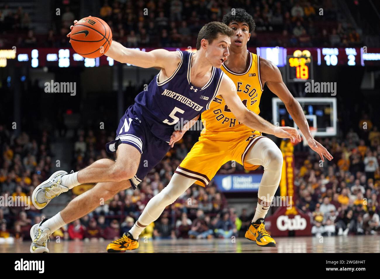 Northwestern guard Ryan Langborg (5) works toward the basket as Minnesota guard Cam Christie ...