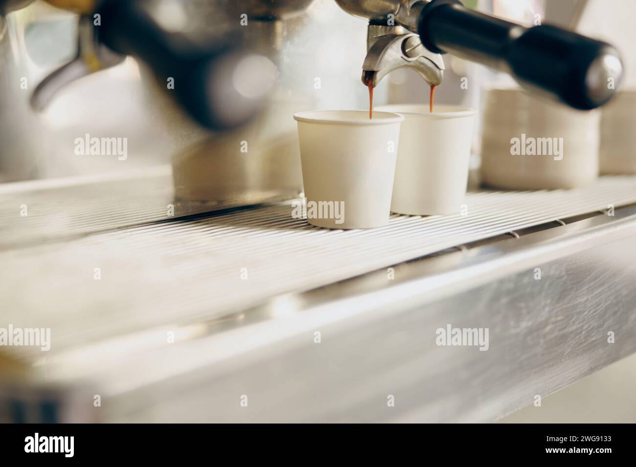Coffee machine filling a two cups with espresso in professional coffee ...
