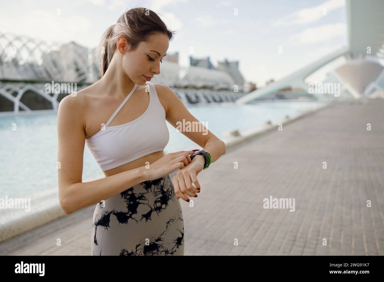 Young fit woman looking at smartwatch and counting calories burned ...