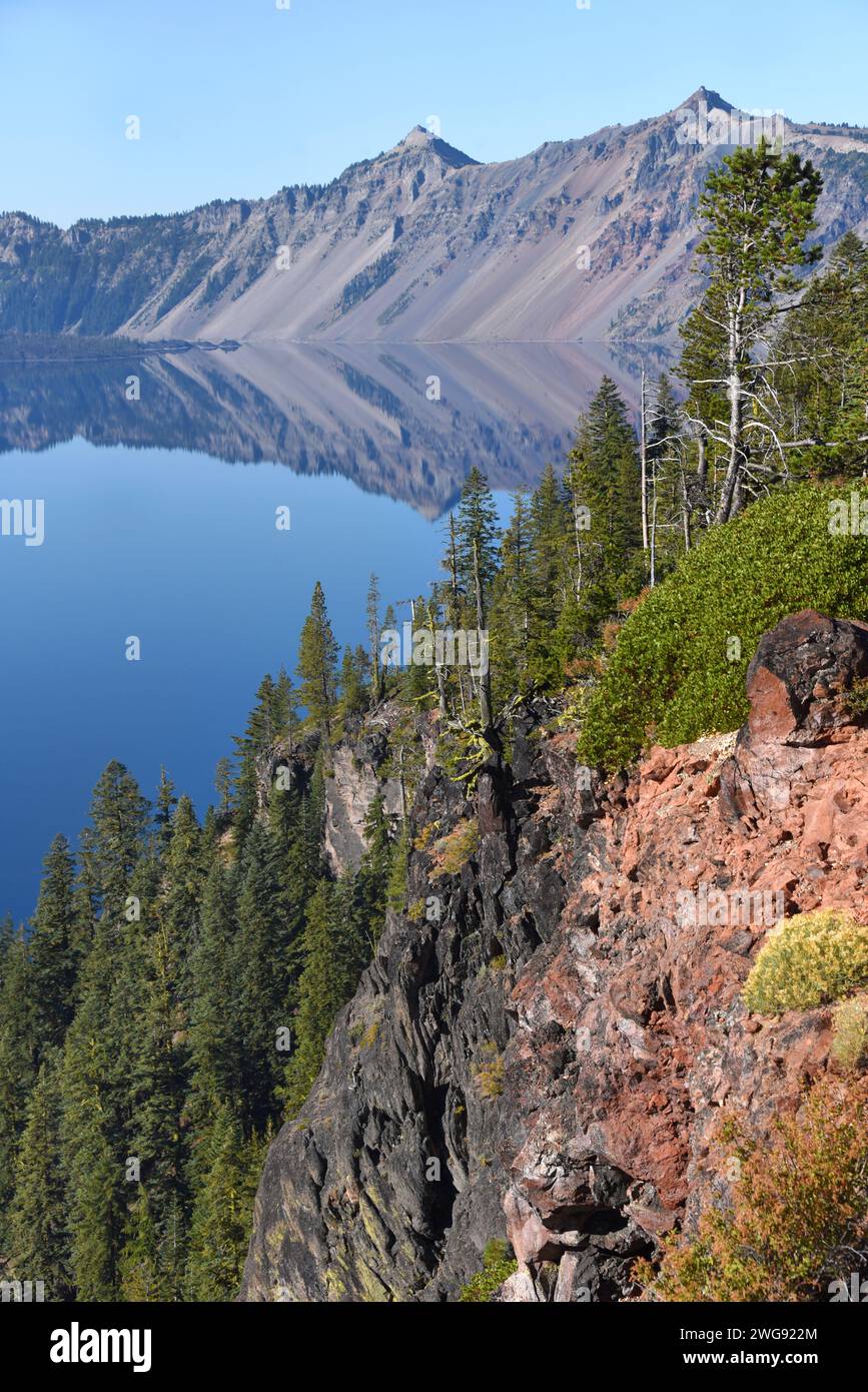 Pumice slopes reflect in the glassy surface of Crater Lake in Crater ...