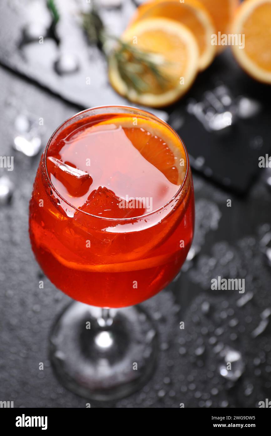 Glass of tasty Aperol spritz cocktail with orange slices and ice cubes ...