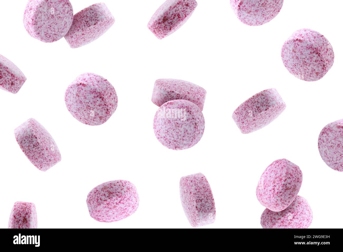 Vitamin. Pink tablets falling on white background Stock Photo - Alamy
