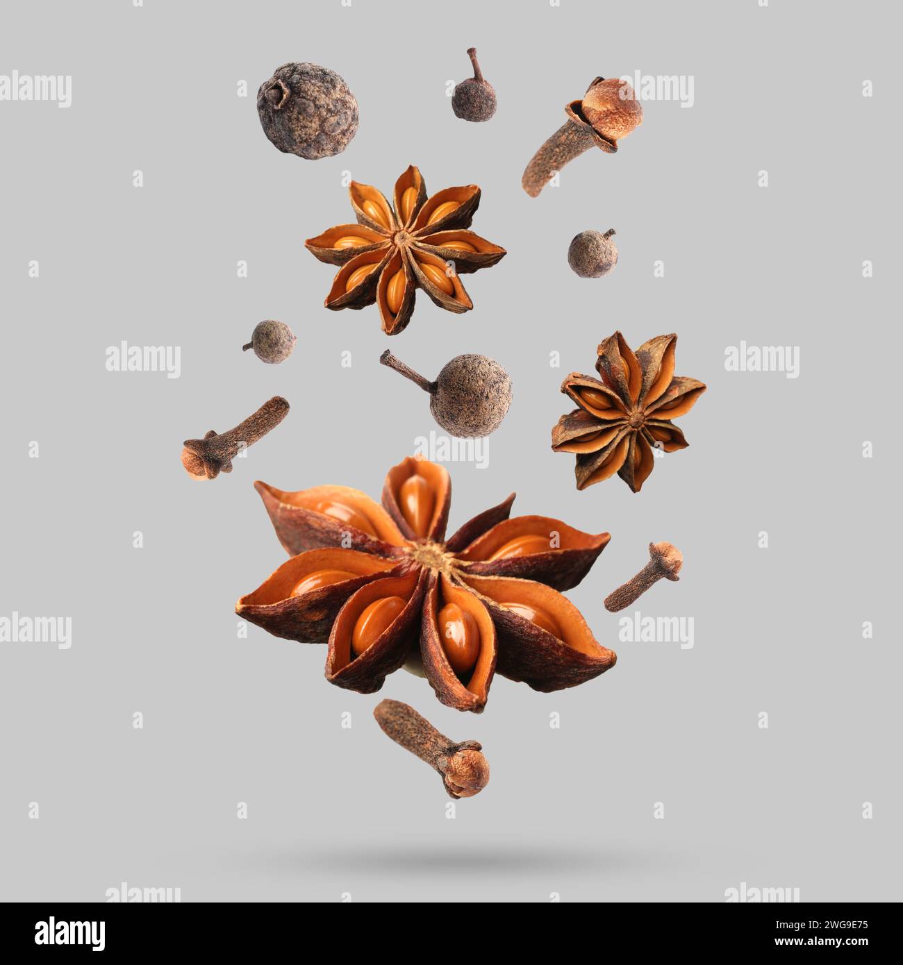 Different spices falling on light grey background Stock Photo - Alamy