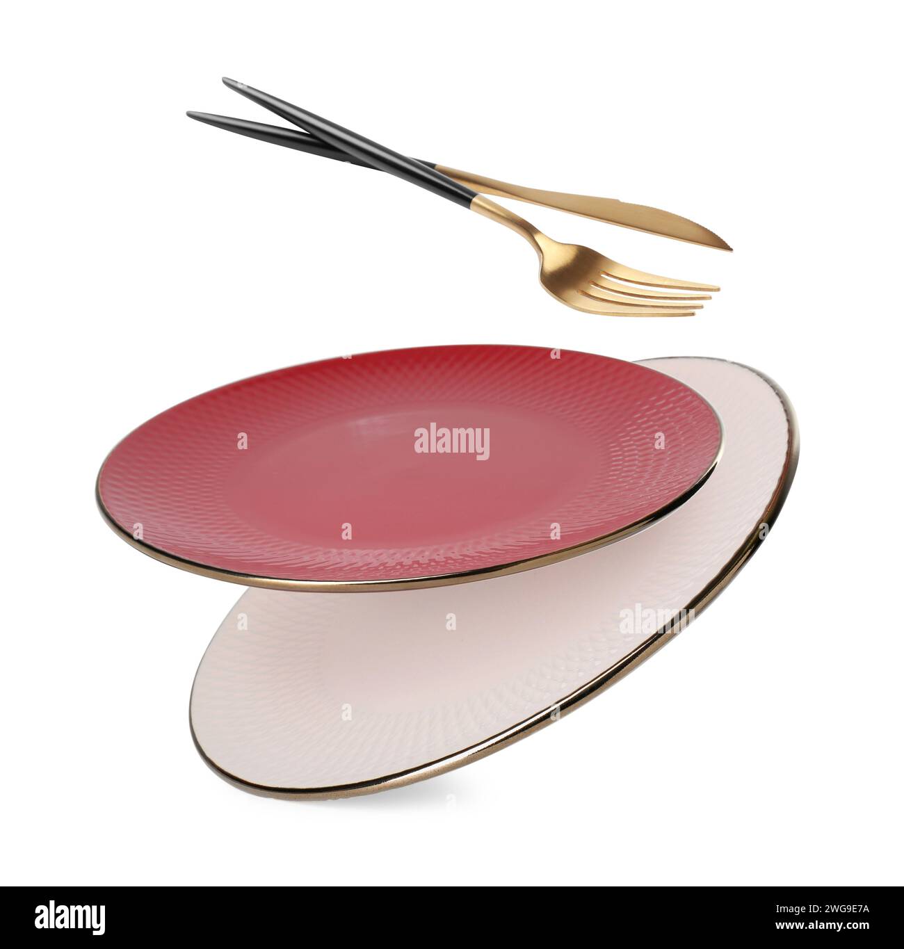 Clean plates, fork and knife falling on white background Stock Photo ...