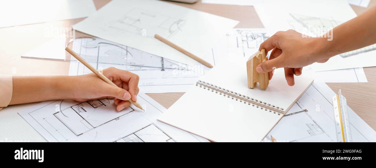 Professional architect hand draws a blueprint on table with ...