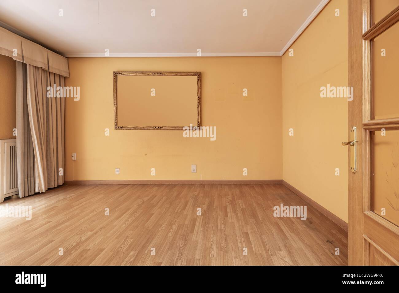 Empty room with walls painted a soft cream color, plaster moldings on ...