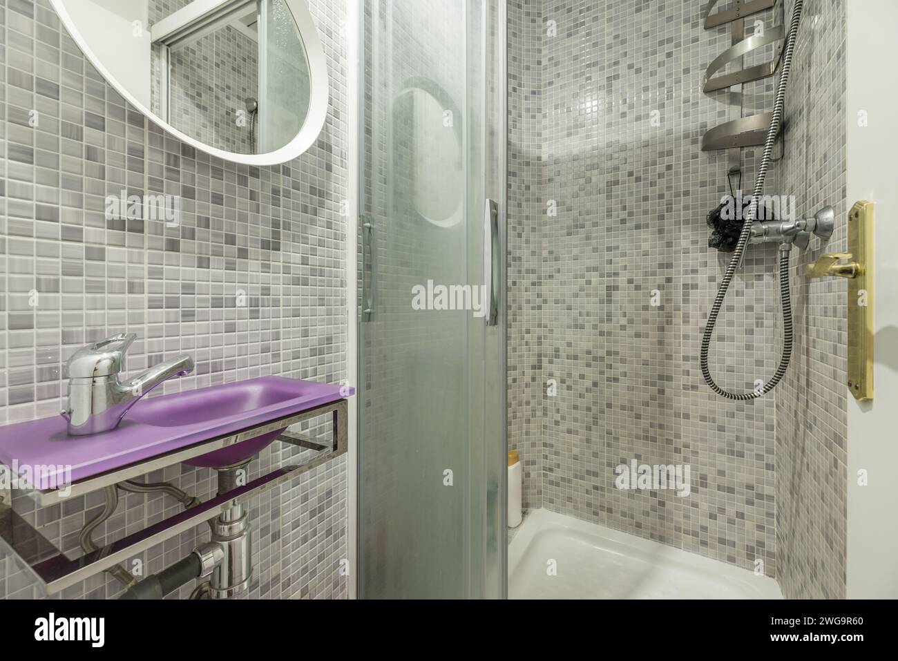 A small bathroom with fuchsia tinted glass sink, beneath a white ...