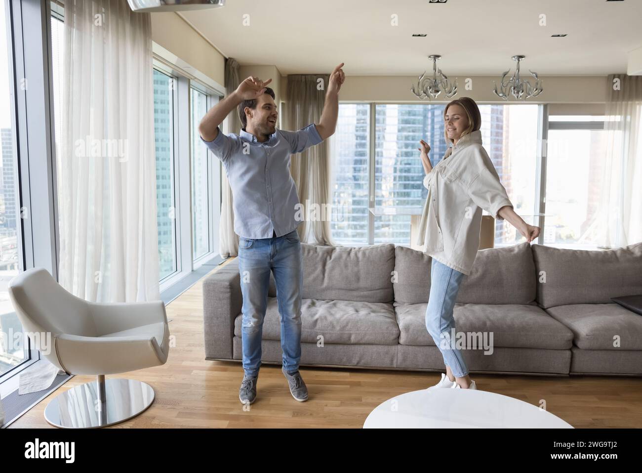 Happy couple dancing in modern living room Stock Photo - Alamy