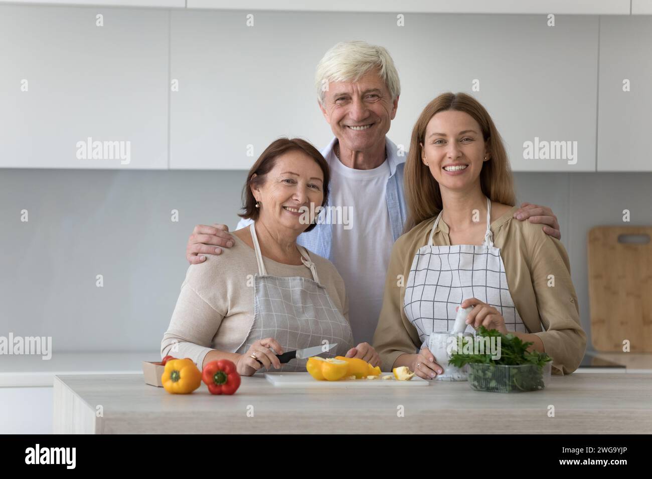 Happy mature old parents and adult kid cooking family dinner Stock ...