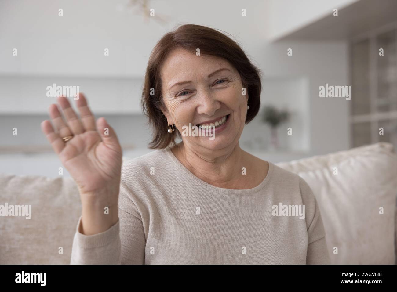 Positive mature older woman smiling at camera, waving hand hello Stock ...