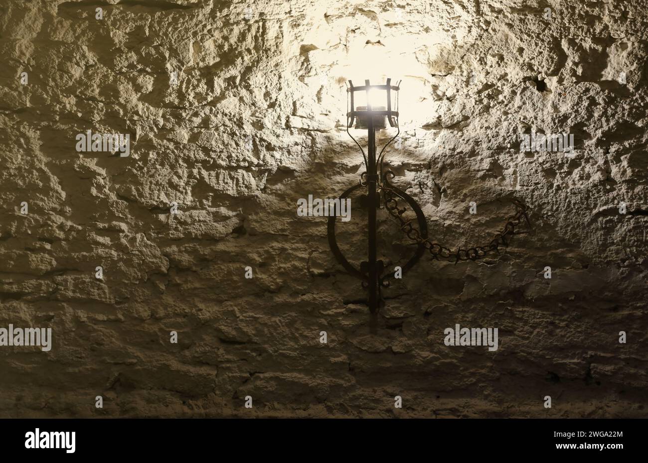 Lighted medieval castle torch hanging on a stone wall, vintage objects ...