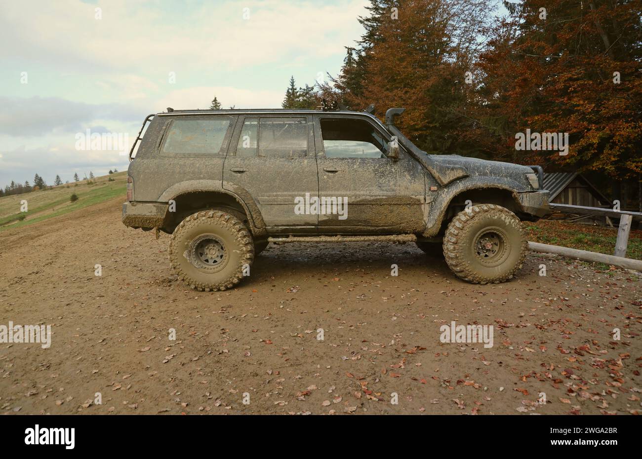 Automobile in a countryside landscape with a mud road. Off-road 4x4 suv ...