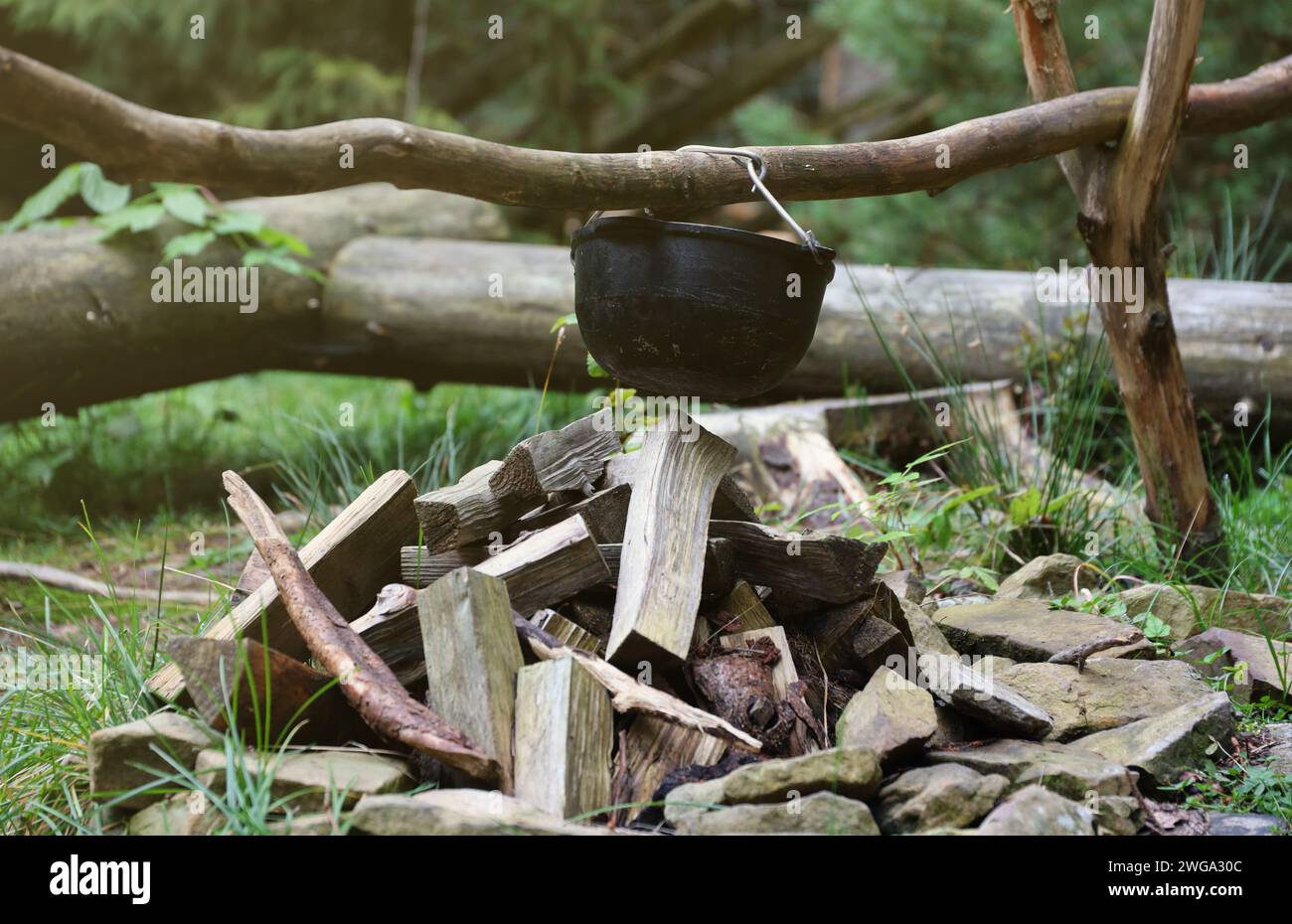 Tourist pot hanging over the fire on a tripod. Cooking in the campaign ...
