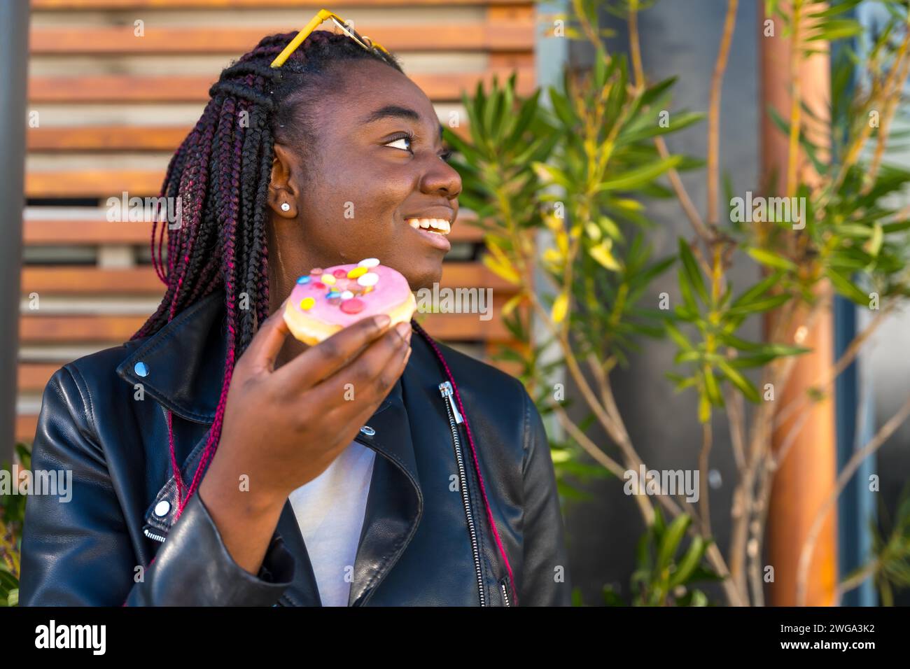 Close-up portrait of a distracted african girl with leather jacket ...