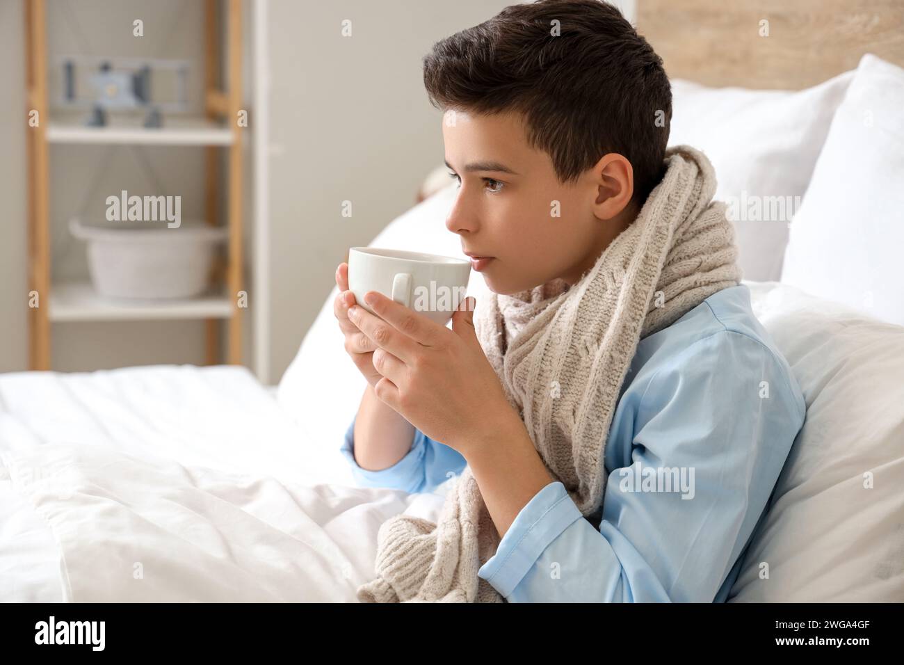 Sick little boy drinking tea in bedroom Stock Photo - Alamy