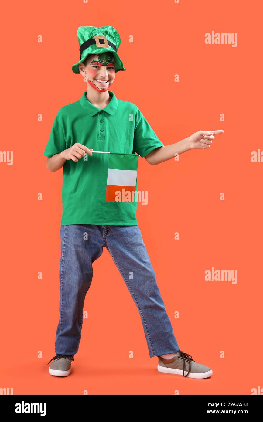 Funny boy with face painting, leprechaun's hat and flag of Ireland ...