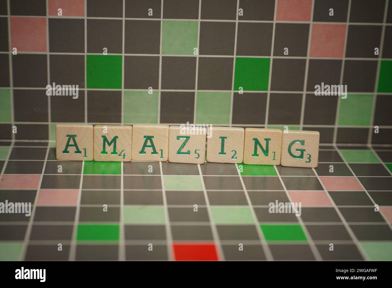 Wooden tile with green amazing text on a blocked background Stock Photo ...