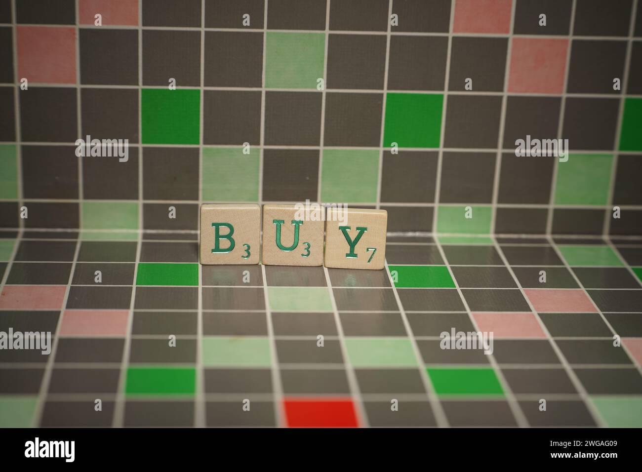 Wooden tile with green buy text on a blocked background Stock Photo - Alamy