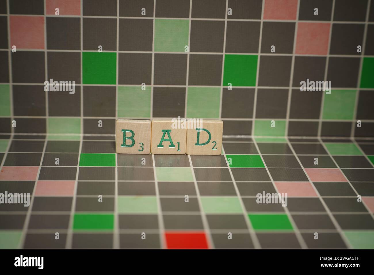 Wooden tile with green bad text on a blocked background Stock Photo - Alamy