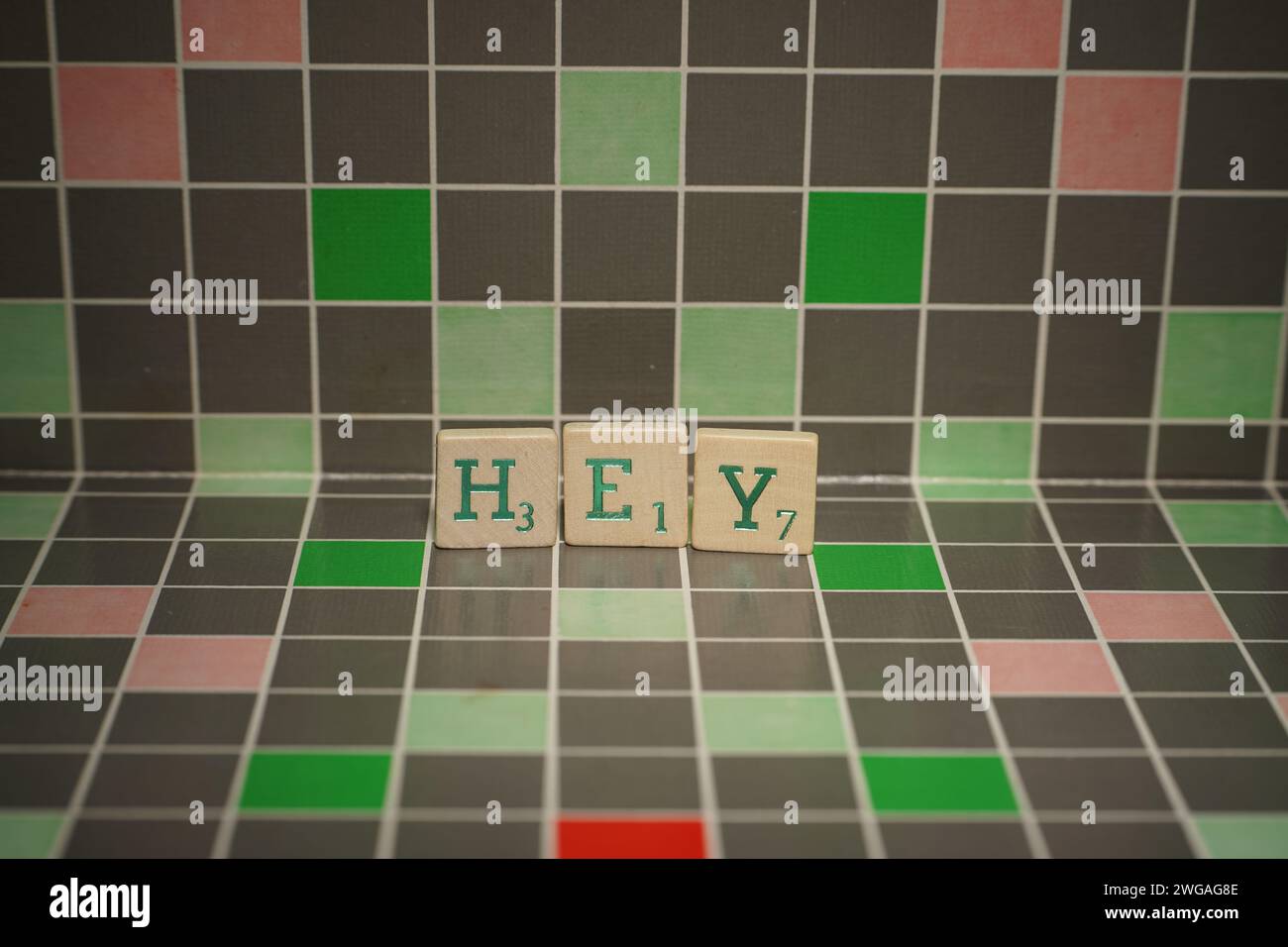 Wooden tile with green hey text on a blocked background Stock Photo - Alamy