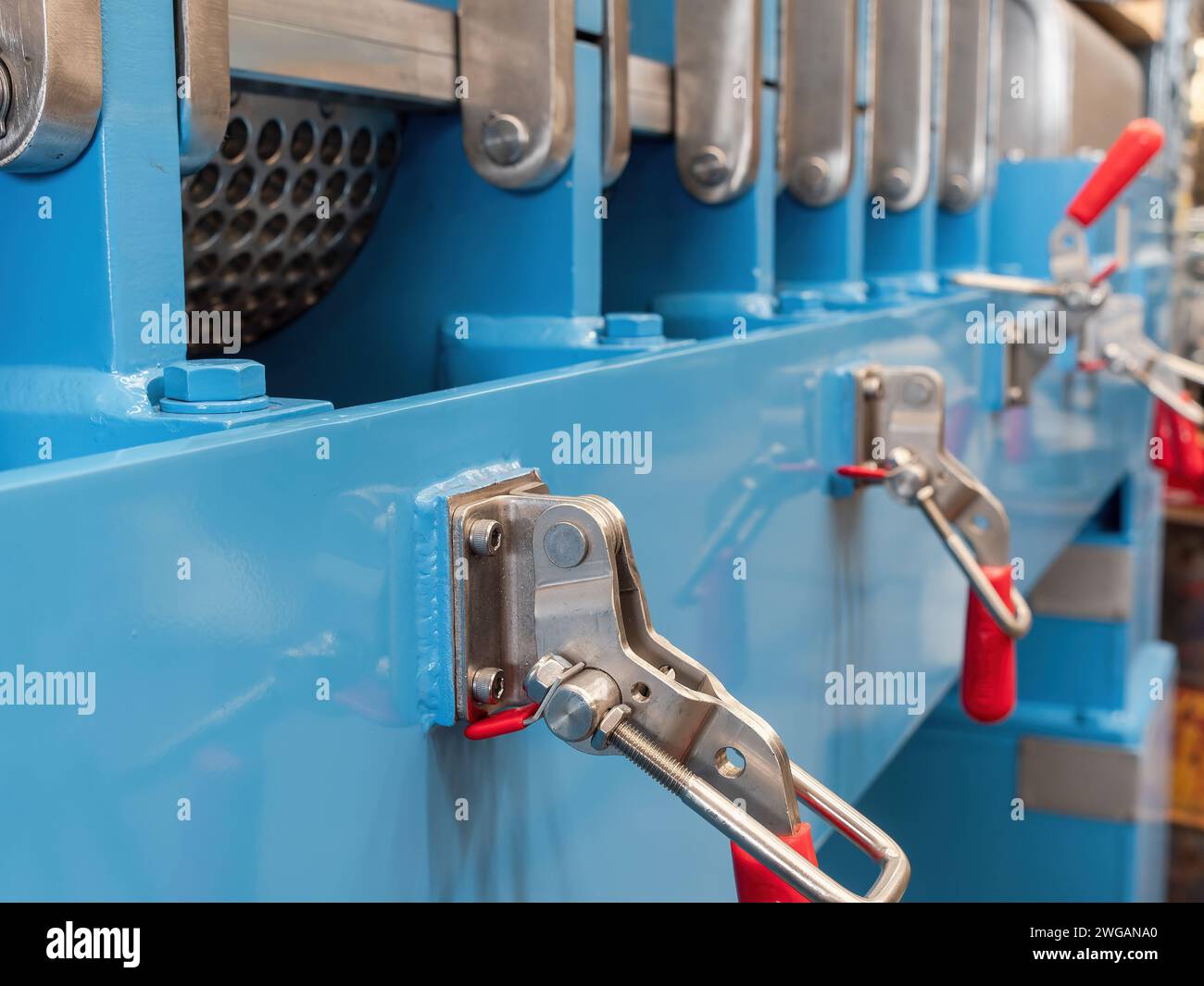 Locking clamps on an industrial twin screw press. Shallow depth of ...