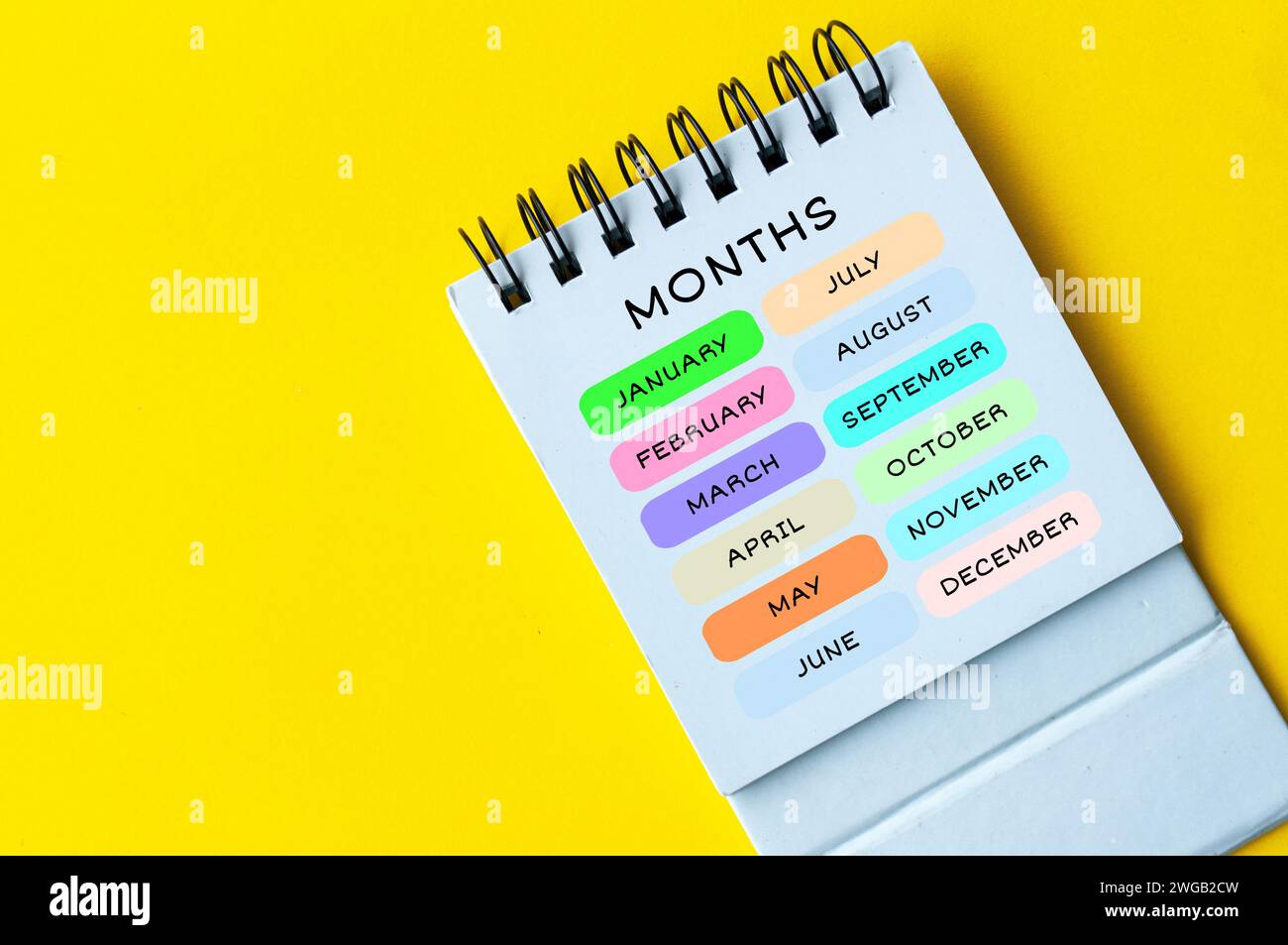 Twelve months calendar text on notepad with yellow cover background ...