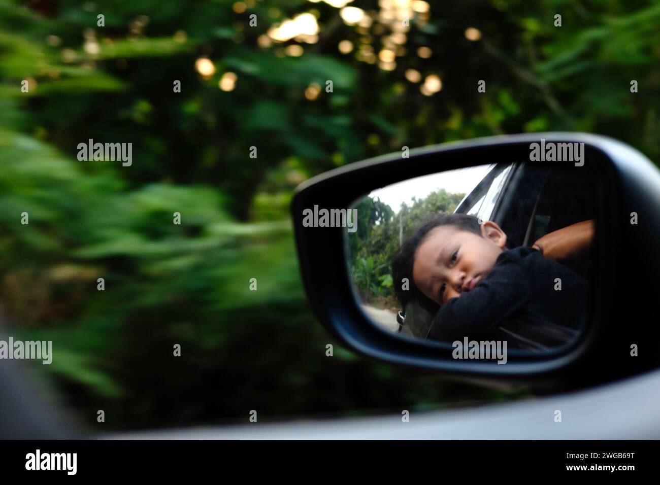 Focus on reflection of Asian kid on car rear view mirror Stock Photo ...