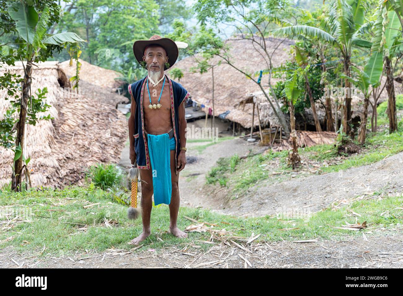 A Man from Wancho Naga tribe in his traditional clothes standing with a ...