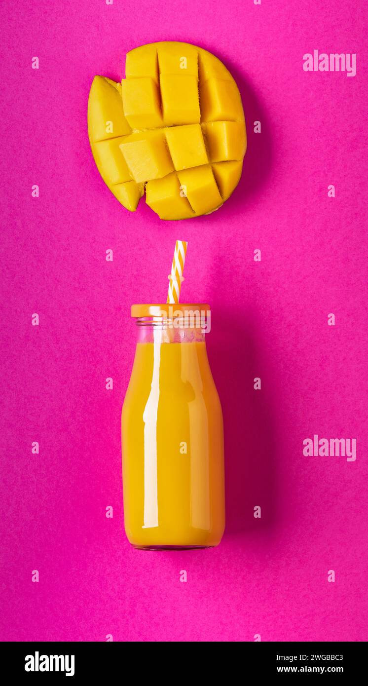 bottled mango juice and portion of fresh mango in pieces isolated from ...