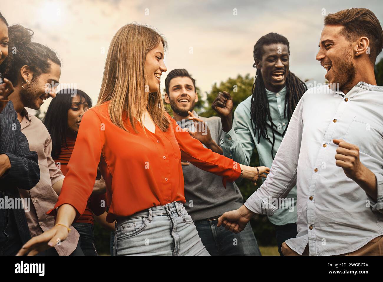 A lively group of young adults laughing and dancing in a natural ...