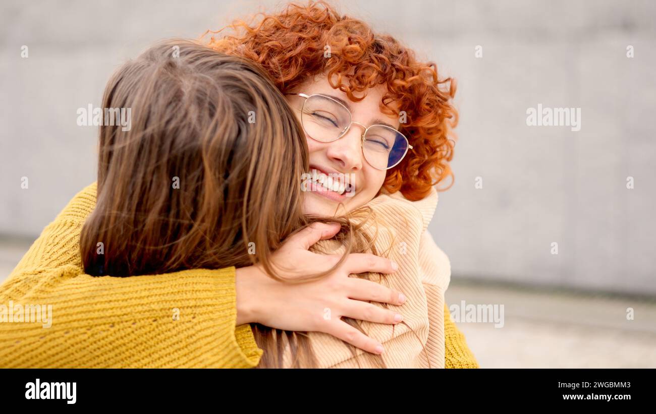 Happy meeting between two young friends in the street Stock Photo - Alamy